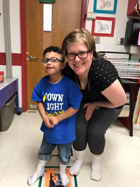 Assistant Principal Comforts Child With Special Needs On Ground ...